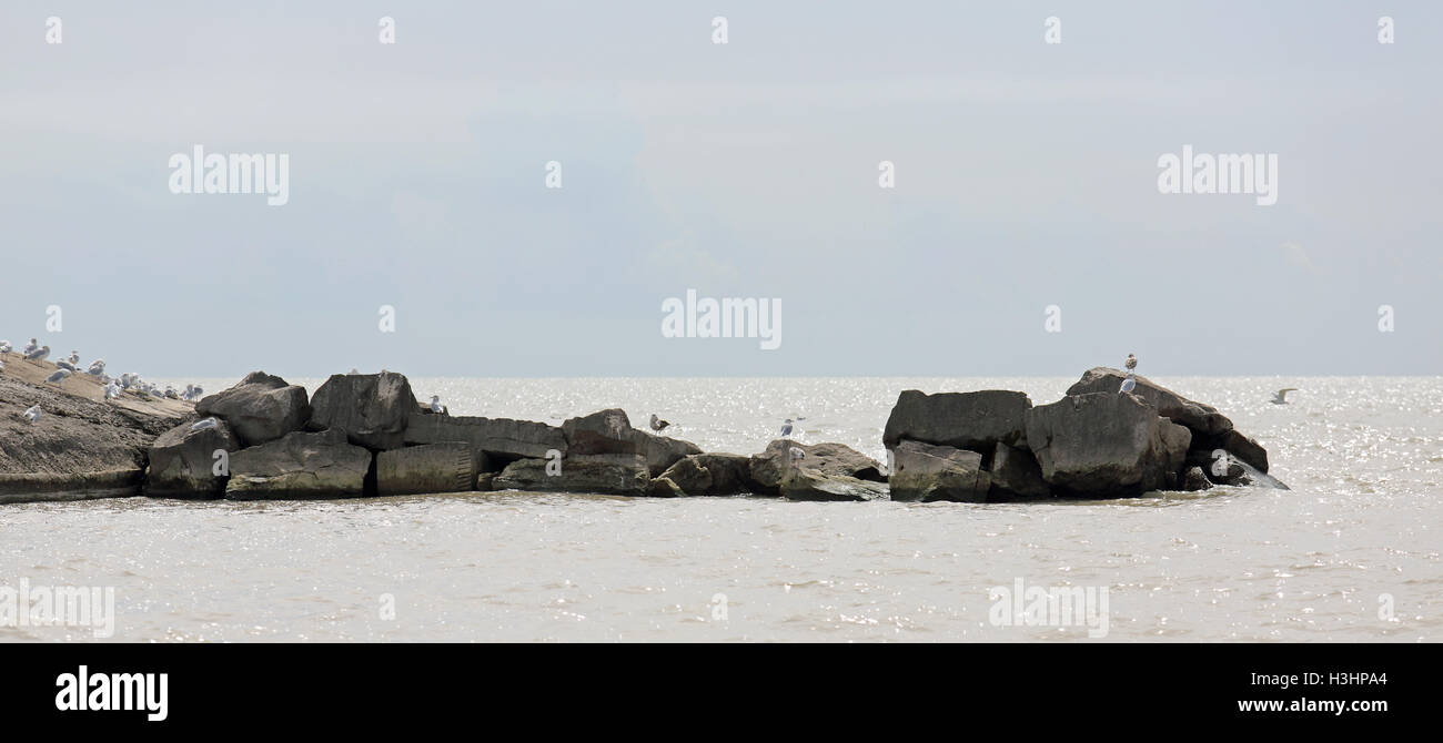 Rock break-wall beside a concrete pier Stock Photo - Alamy