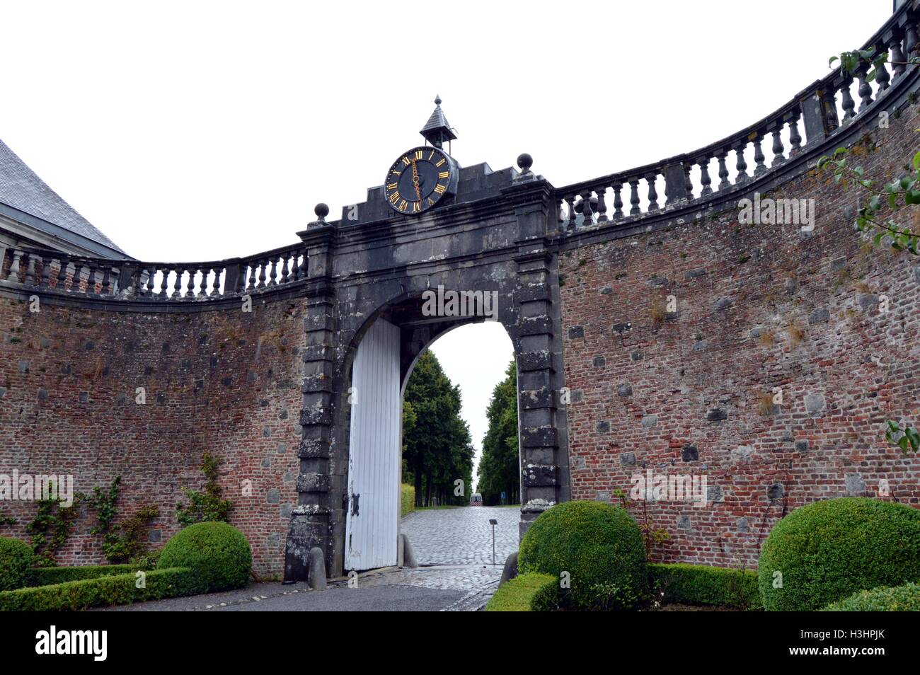 Front door of the castle with a red brick-built wall and an old clock ...