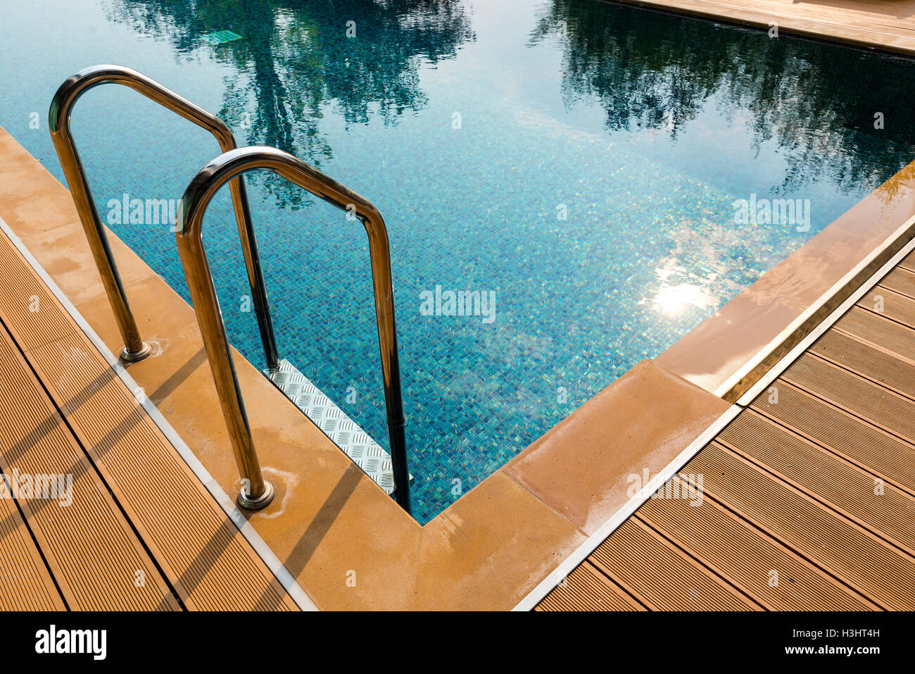 Grab bars metallic ladder entrance to clear blue swimming pool Stock ...