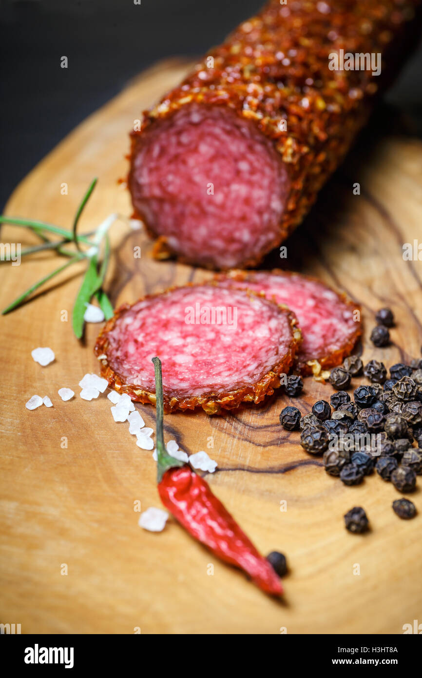 dried salami crusted in ground red pepper on dark background Stock ...