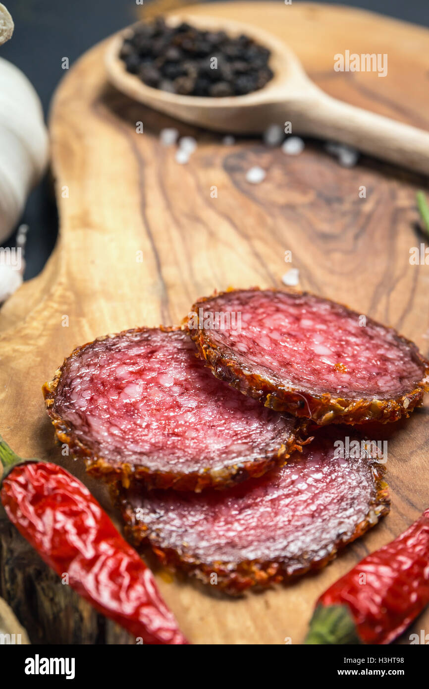 dried salami crusted in ground red pepper on dark background Stock ...