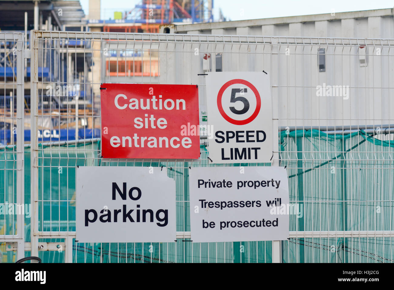 Warning signs to public on gates to construction site Stock Photo - Alamy