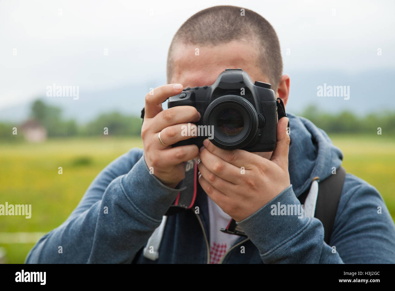 Man holding camera and taking photos Stock Photo - Alamy