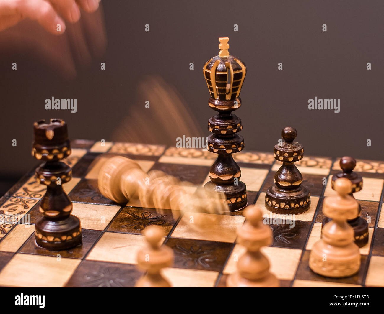 White gives up a lost game of chess and throws down the king. Black ...