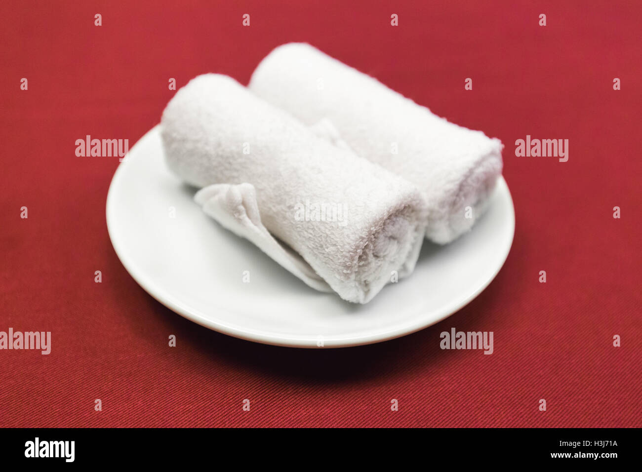 Close focus on white rolled napkin made from rough cotton inside white ...
