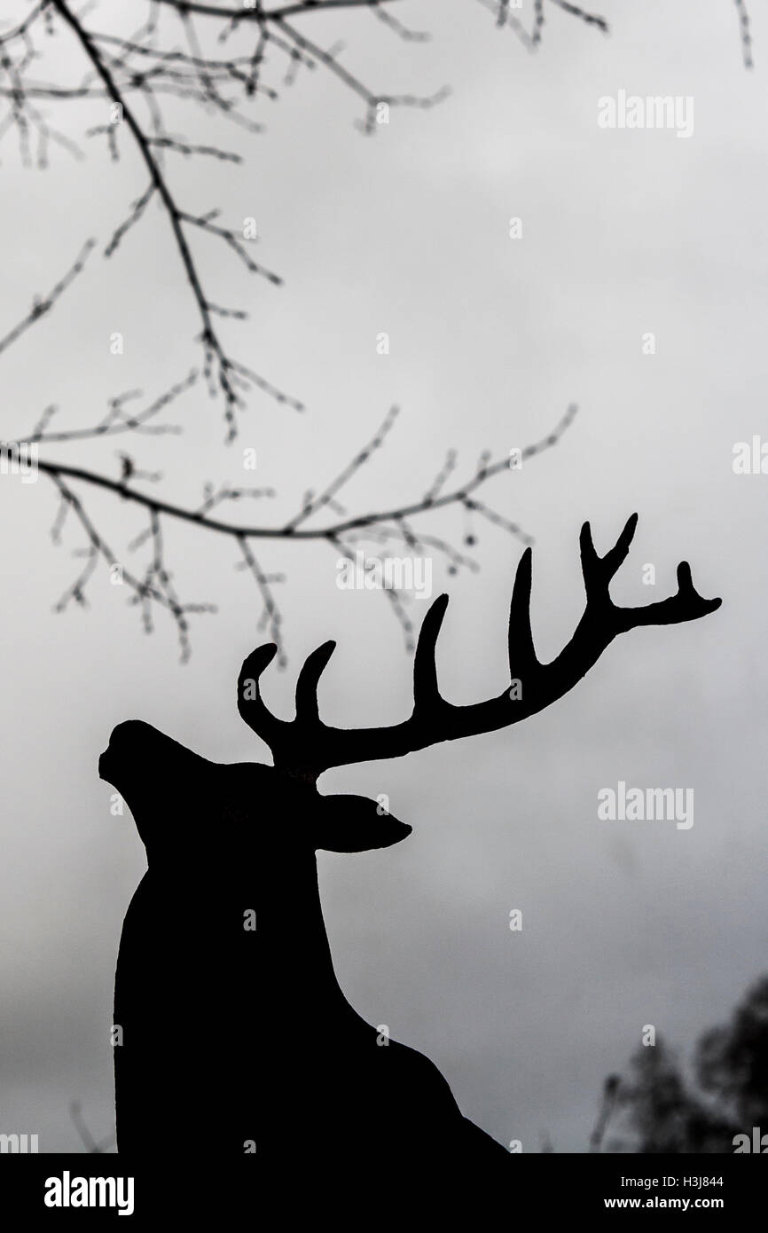 Silhouette of black reindeer with blurred branches and grey sky Stock ...