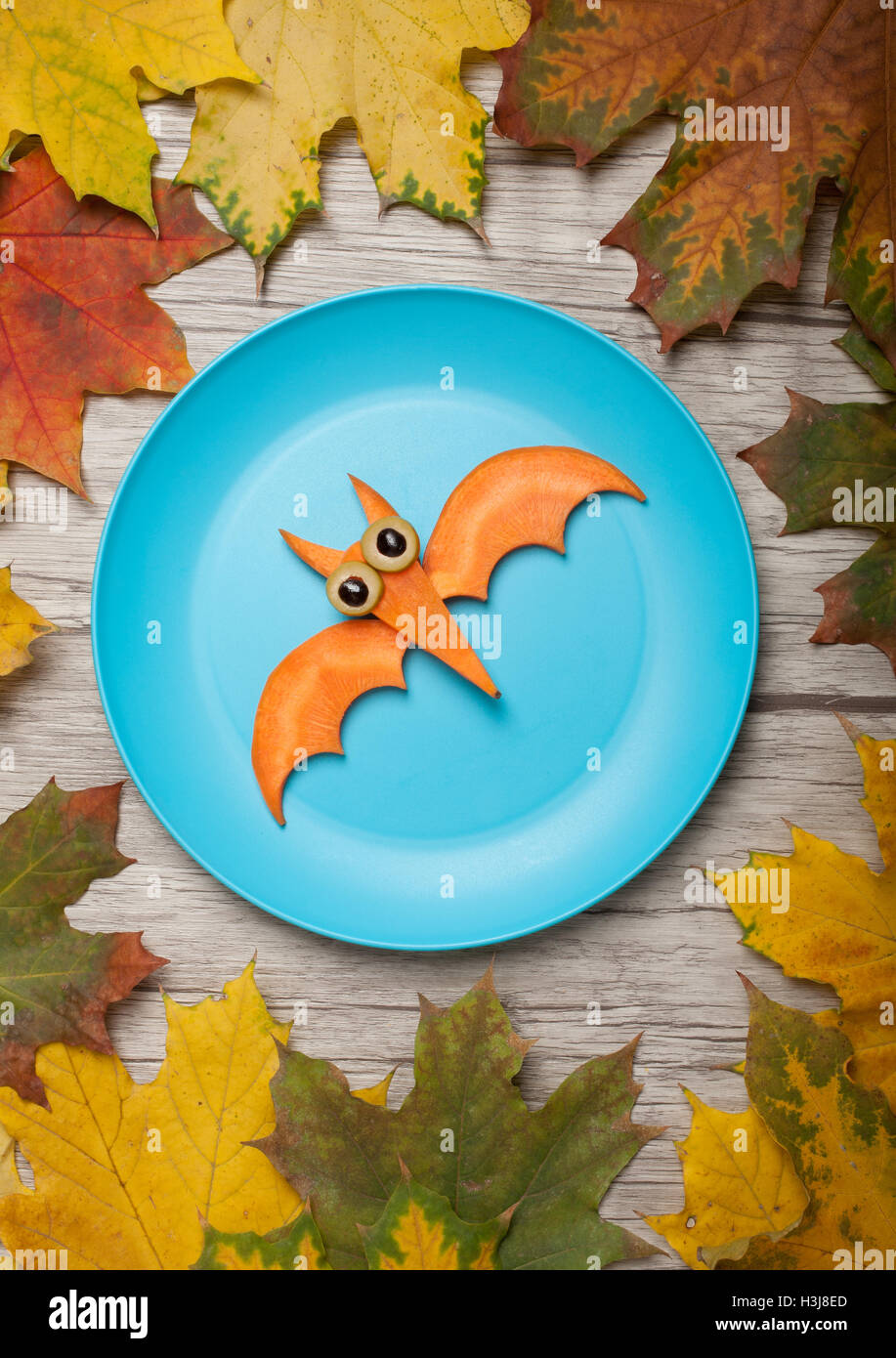 Flying bat made of carrot on plate and autumn background Stock Photo ...