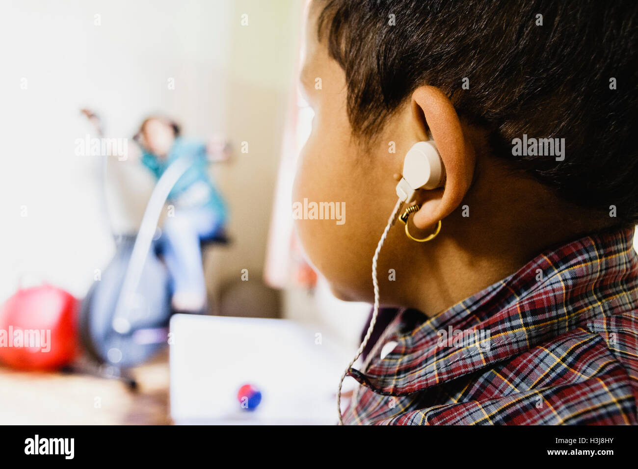 An almost totally deaf child wearing double hearing aid. Swarga Stock ...