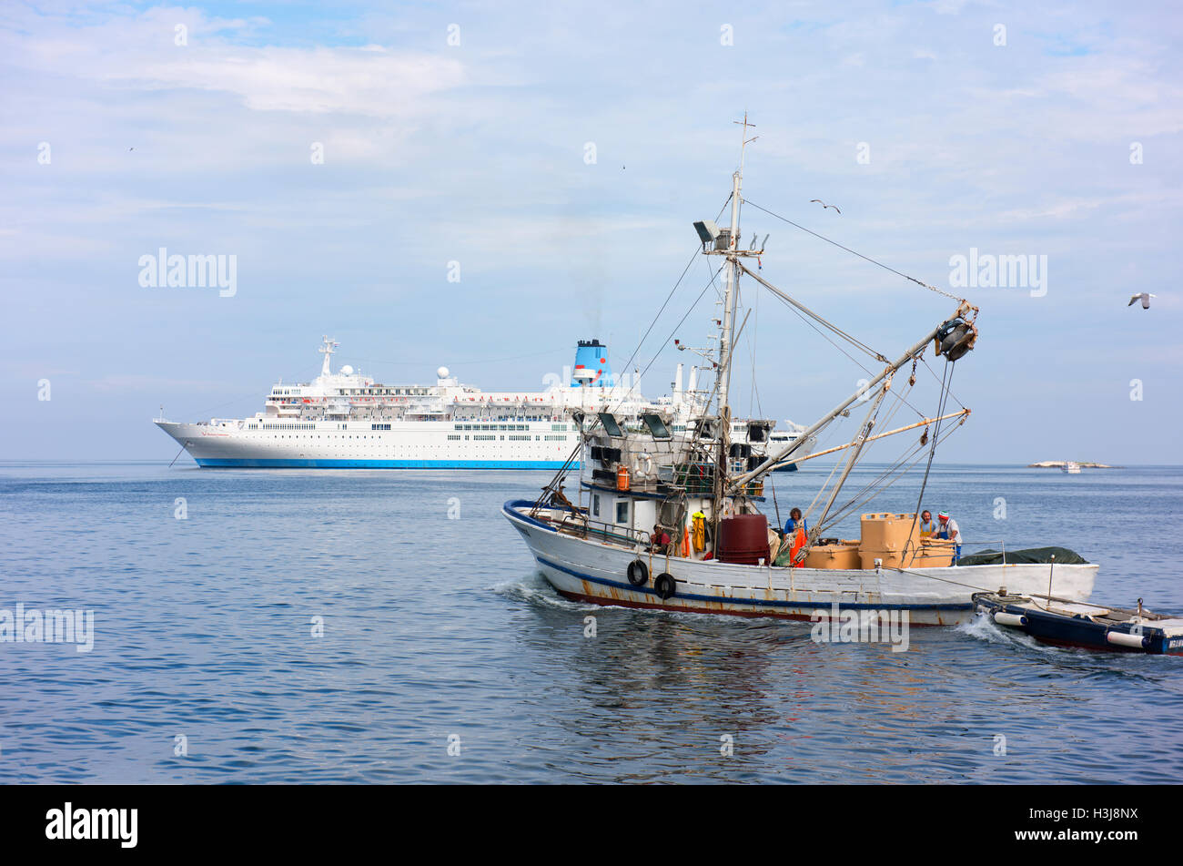Fishing trawler and modern cruise ship off Rovinj Stock Photo - Alamy