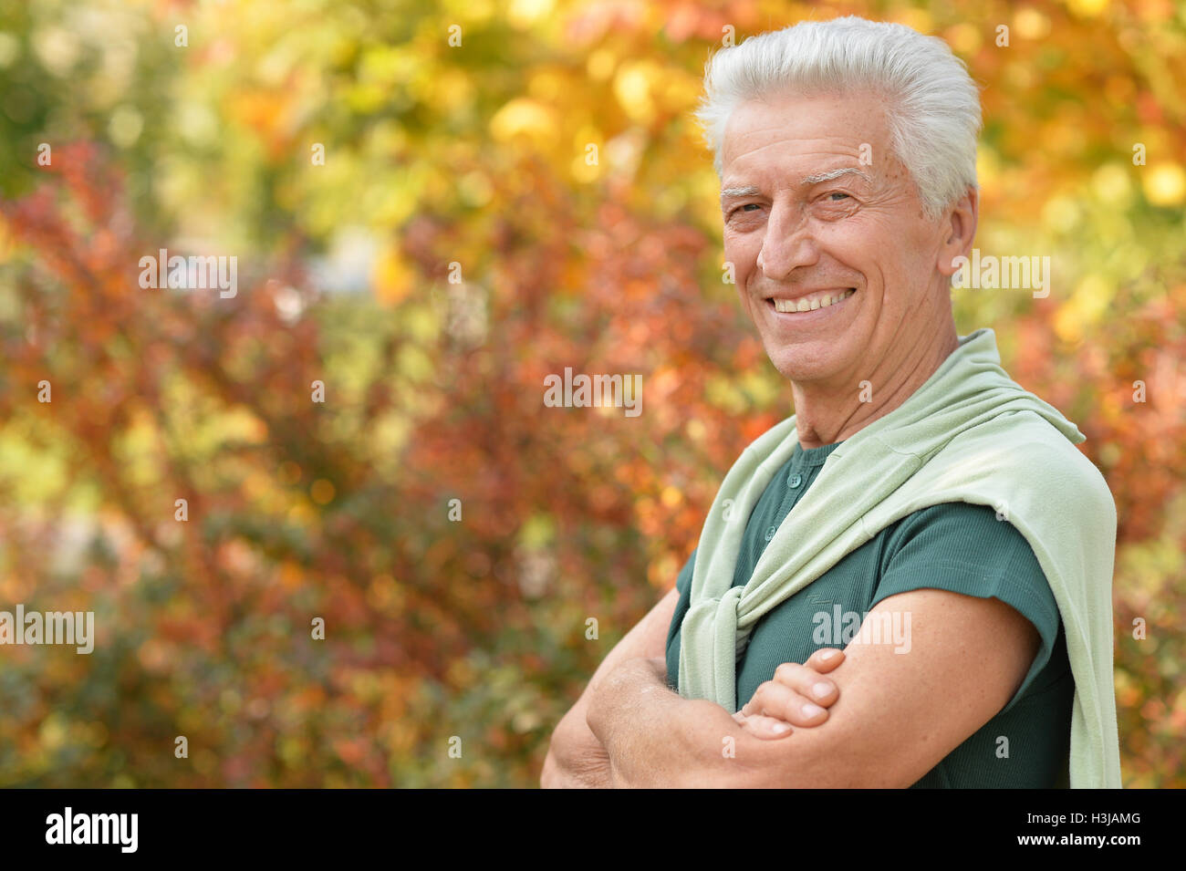 Smiling elderly man in autumn park Stock Photo - Alamy