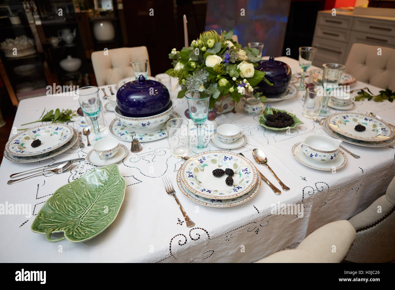 Beautifully decorated table set with flowers, candles, plates and ...