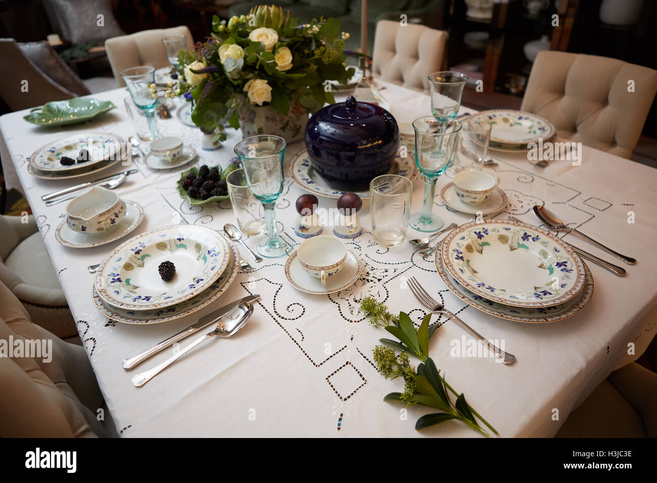 Beautifully decorated table set with flowers, candles, plates and ...