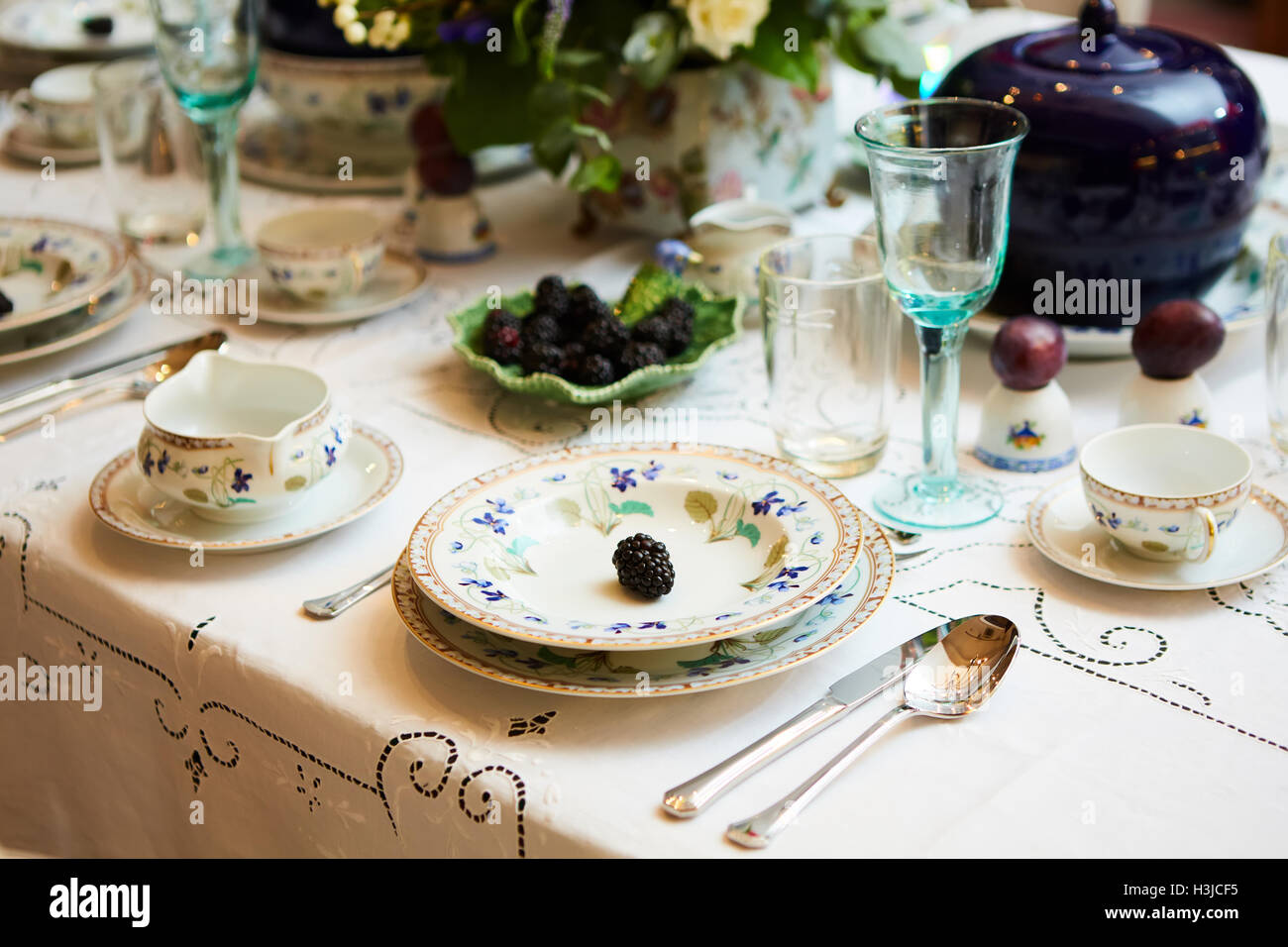 Beautifully decorated table set with flowers, candles, plates and ...