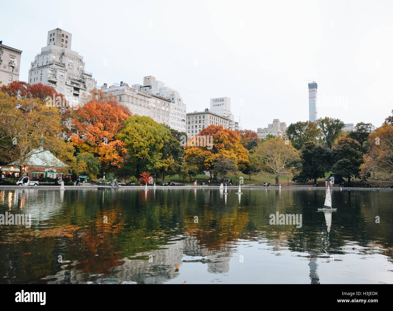 View of Central Park during fall with reflection of buildings and trees ...