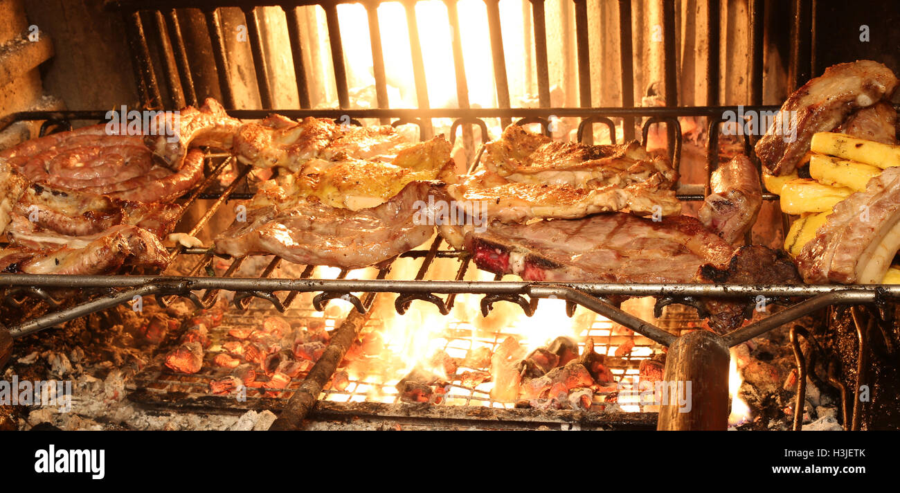 cooking the meat on the grill in the large fireplace in the restaurant ...