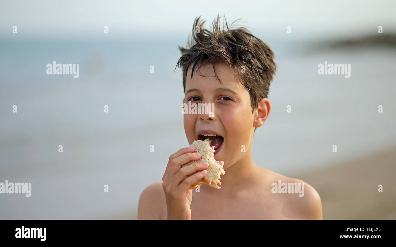 nice guy while eating a very good sandwich on the beach in summer Stock ... nice guy while eating a very good sandwich on the beach in summer Stock ...