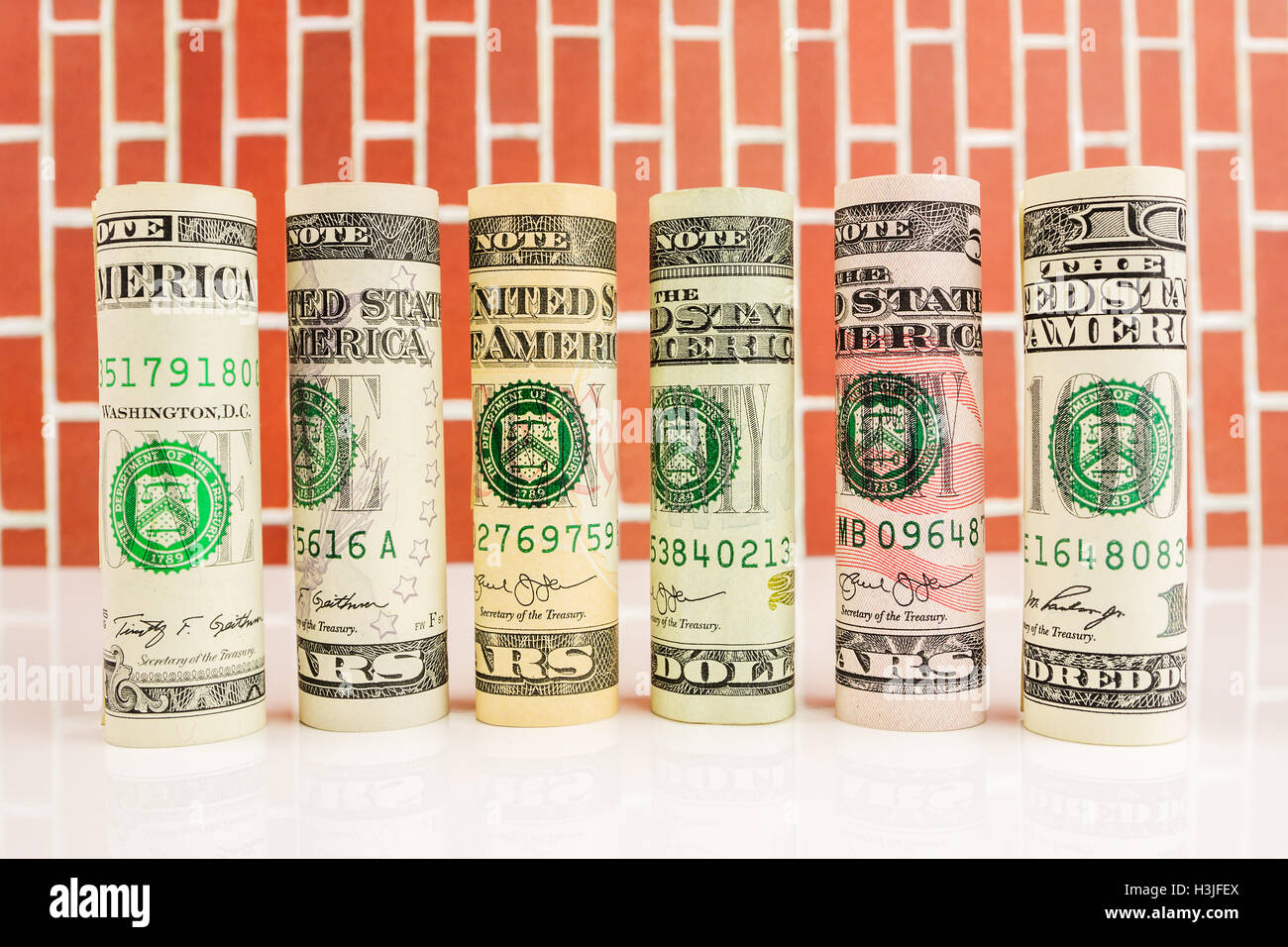 american dollar banknote rolls in all denominations in one row on red ...