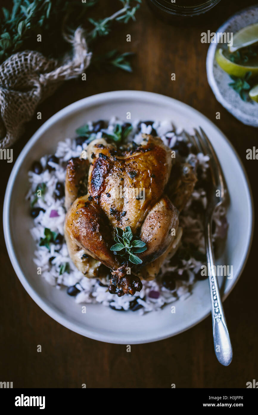 A Cuban Roasted game hen served on black bean rice is photographed from ...