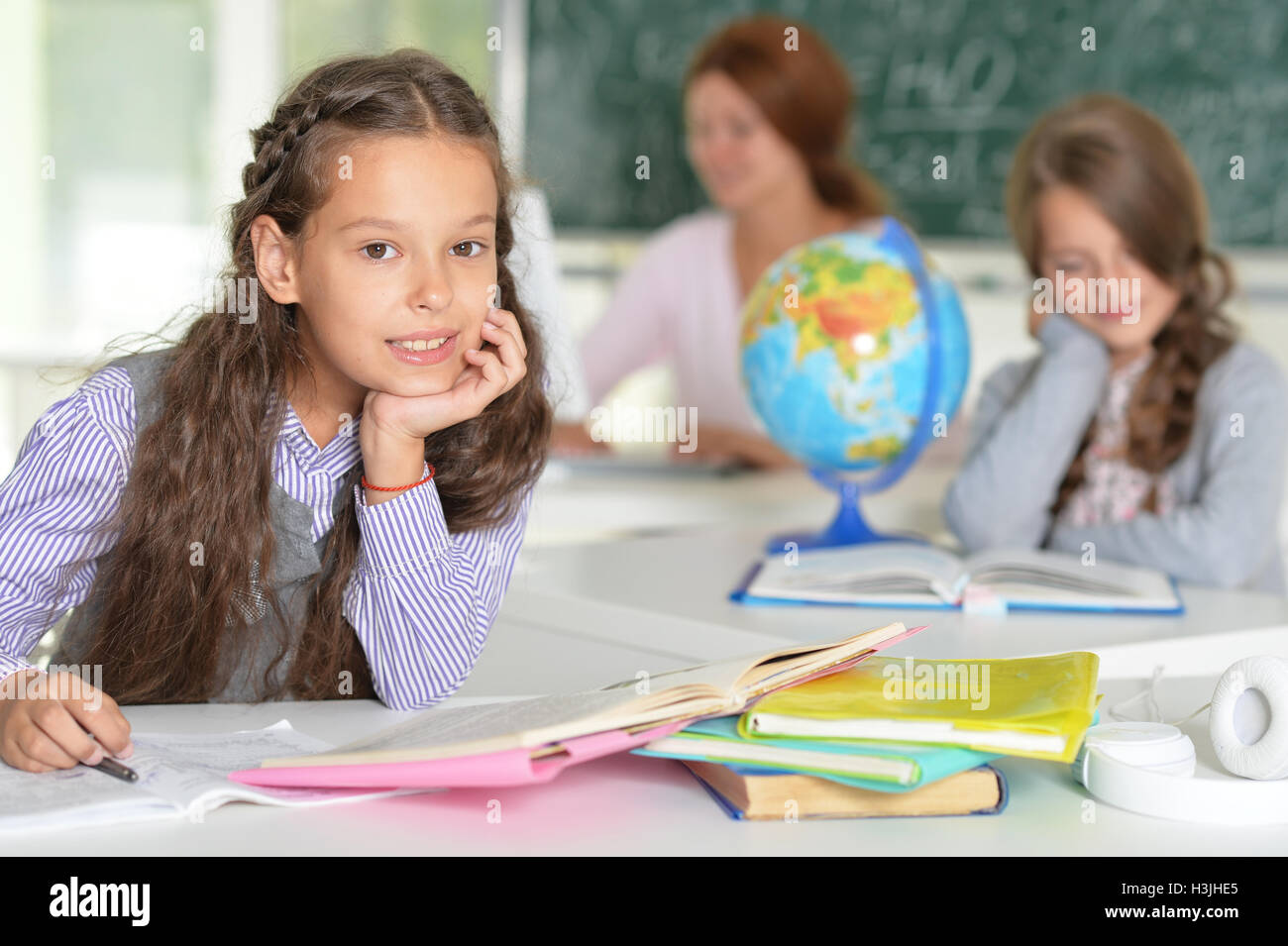 teacher with two girls at lesson Stock Photo - Alamy