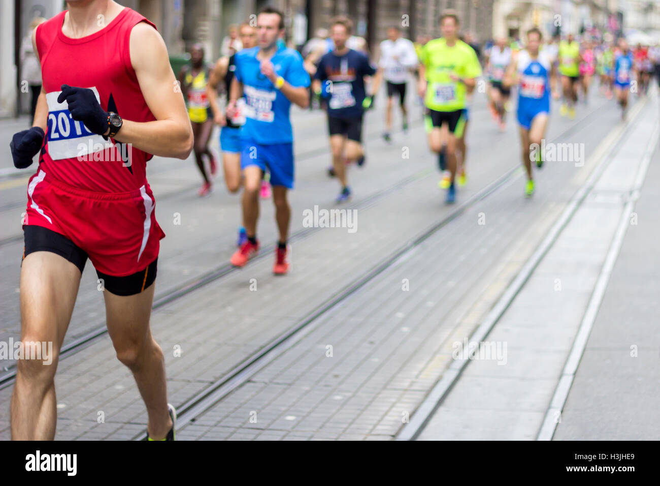 Marathon runners race in city streets, blurred motion Stock Photo - Alamy