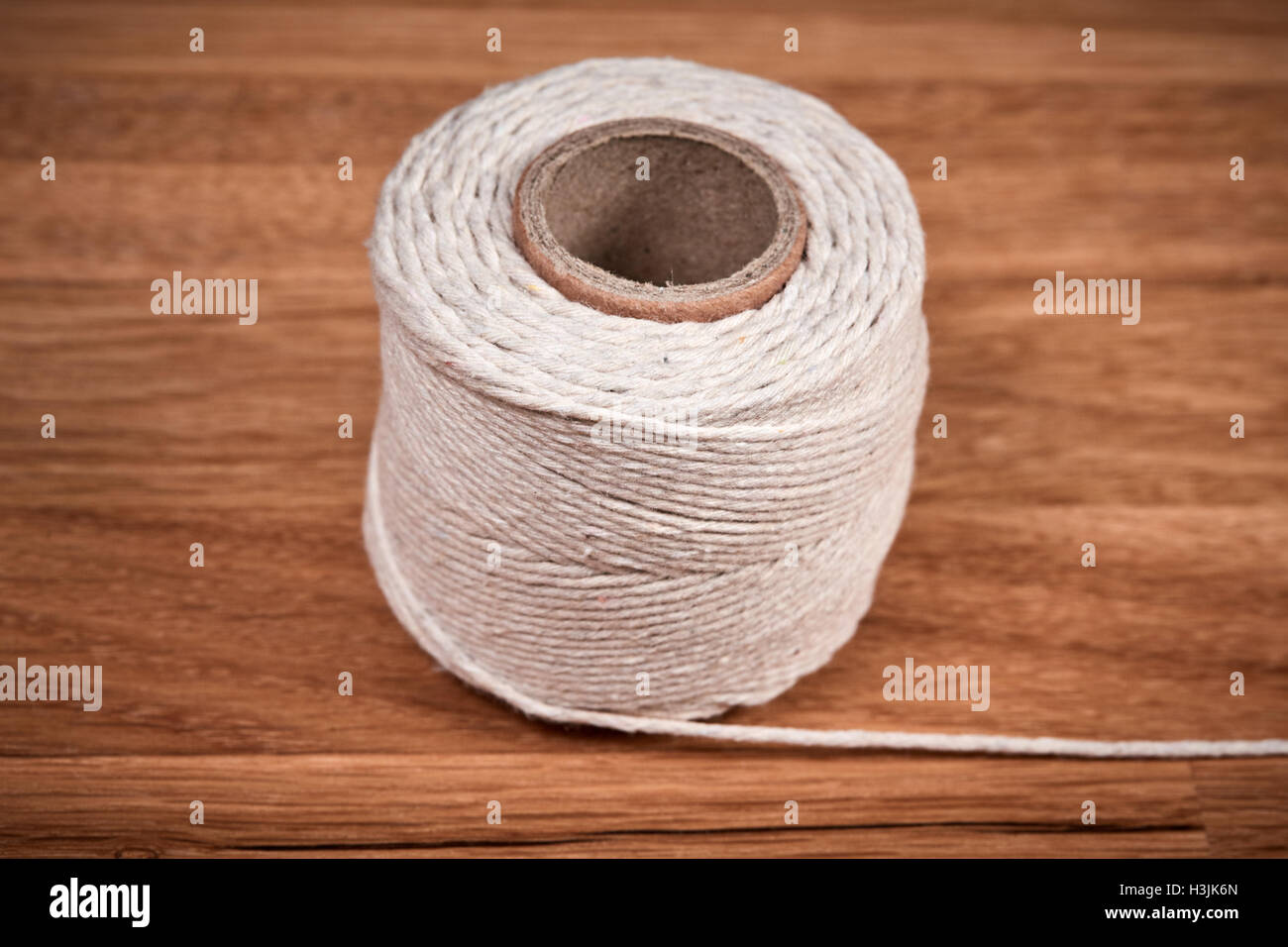 Cord, string or rope on a brown wooden oiled oak plate Stock Photo - Alamy