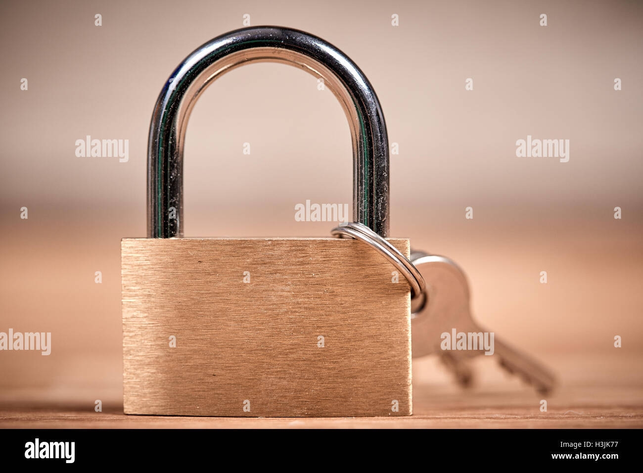 Golden or bronze Padlock and keys on a brown wooden oak table Stock ...