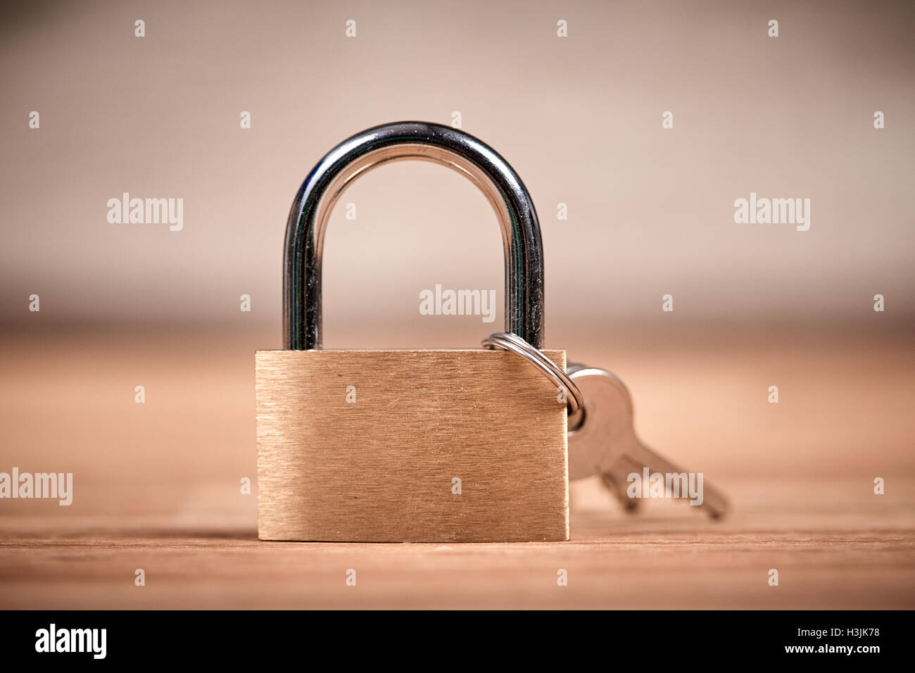 Golden or bronze Padlock and keys on a brown wooden oak table Stock ...