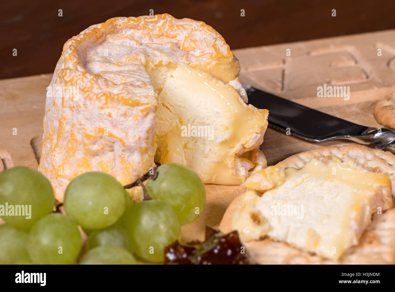 Soft French cheese with grapes Stock Photo - Alamy