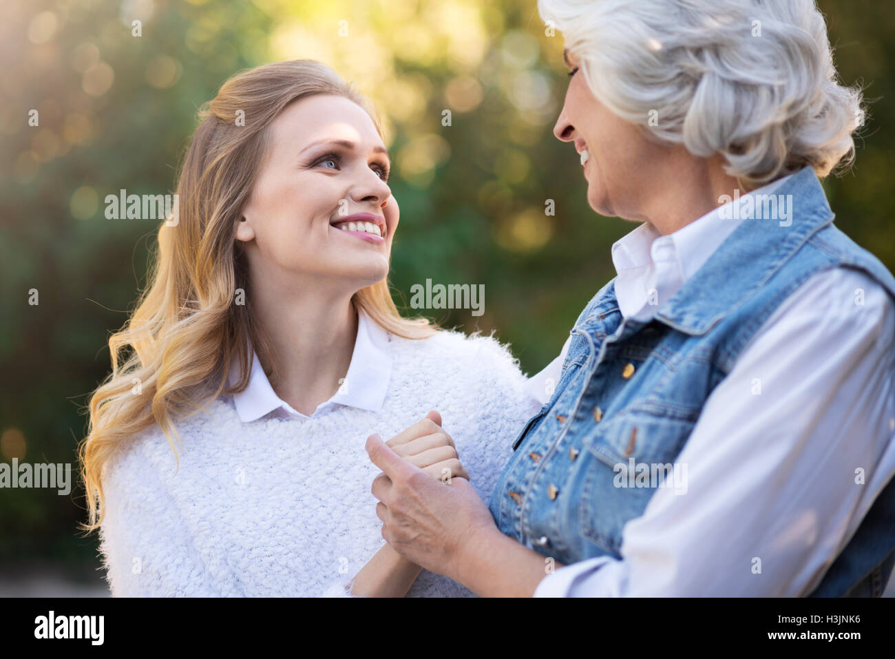 Two joyful women hugging and smiling outdoors Stock Photo - Alamy
