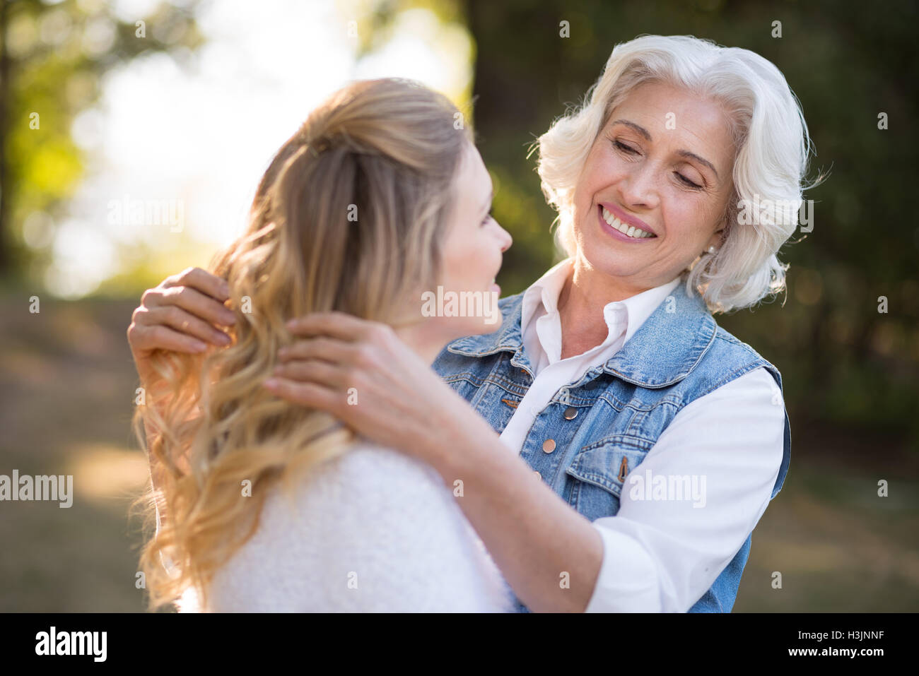 Beautiful old lady playing with hair of her daughter Stock Photo - Alamy