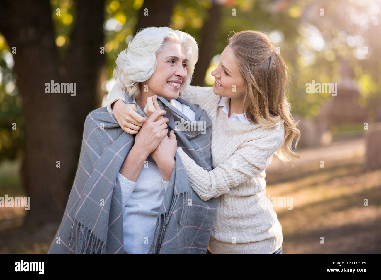 Pretty smiling woman caring about her mother Stock Photo - Alamy