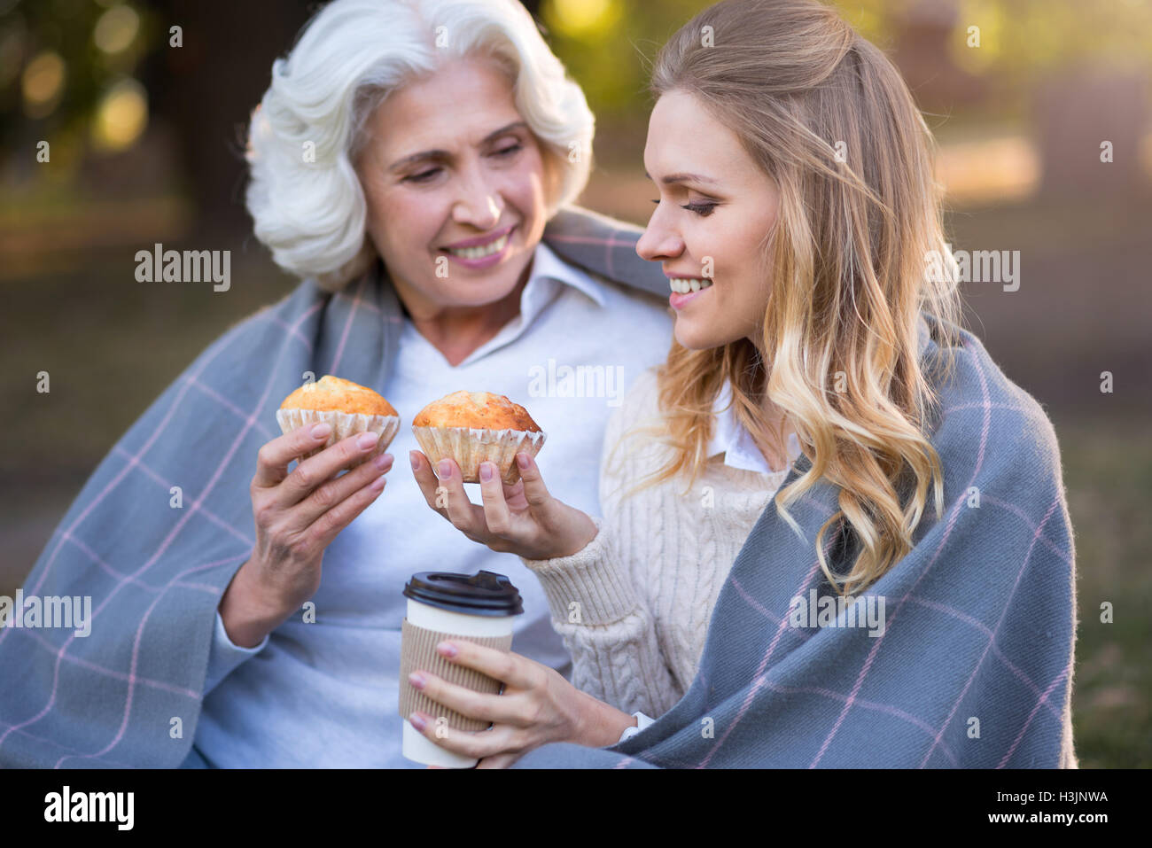 Two charming pleasant women sitting on the ground Stock Photo - Alamy