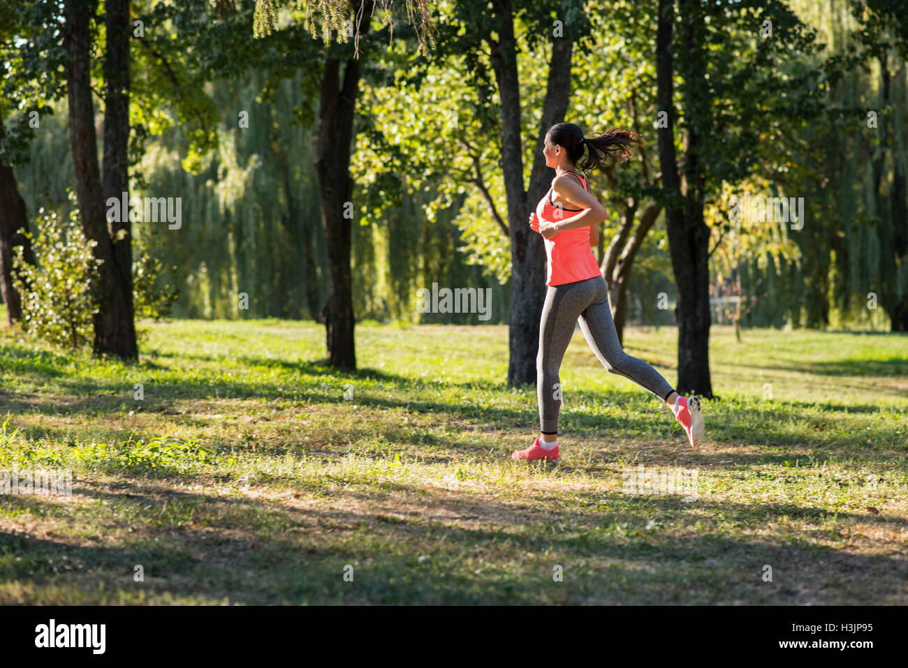 Athletic girl running in the park Stock Photo - Alamy