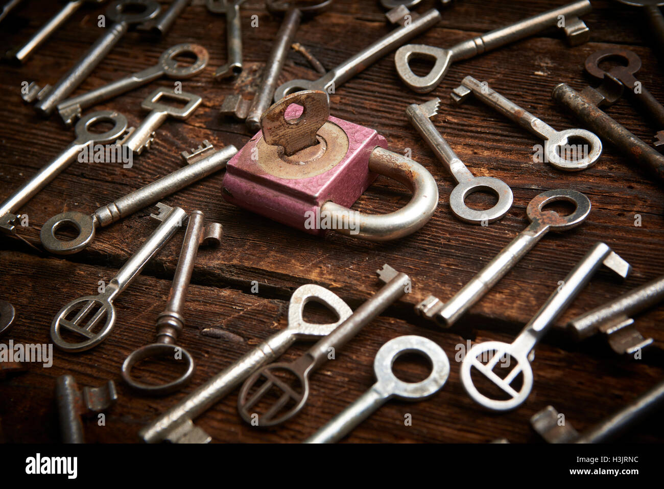 Group of old rusty padlocks with pile of keys on brown wooden table ...