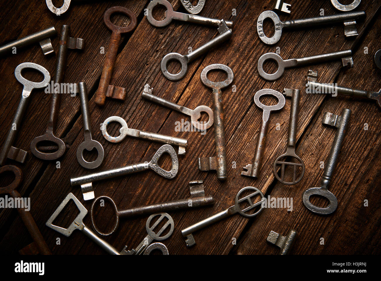 many different keys on brown wooden background Stock Photo - Alamy