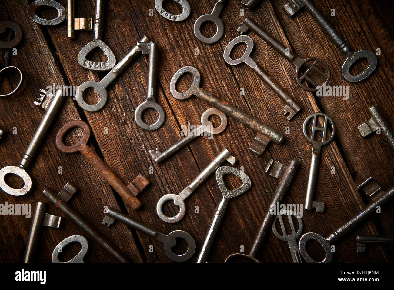 many different keys on brown wooden background Stock Photo - Alamy