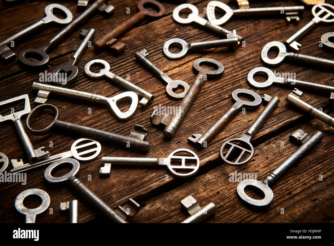 many different keys on brown wooden background Stock Photo - Alamy