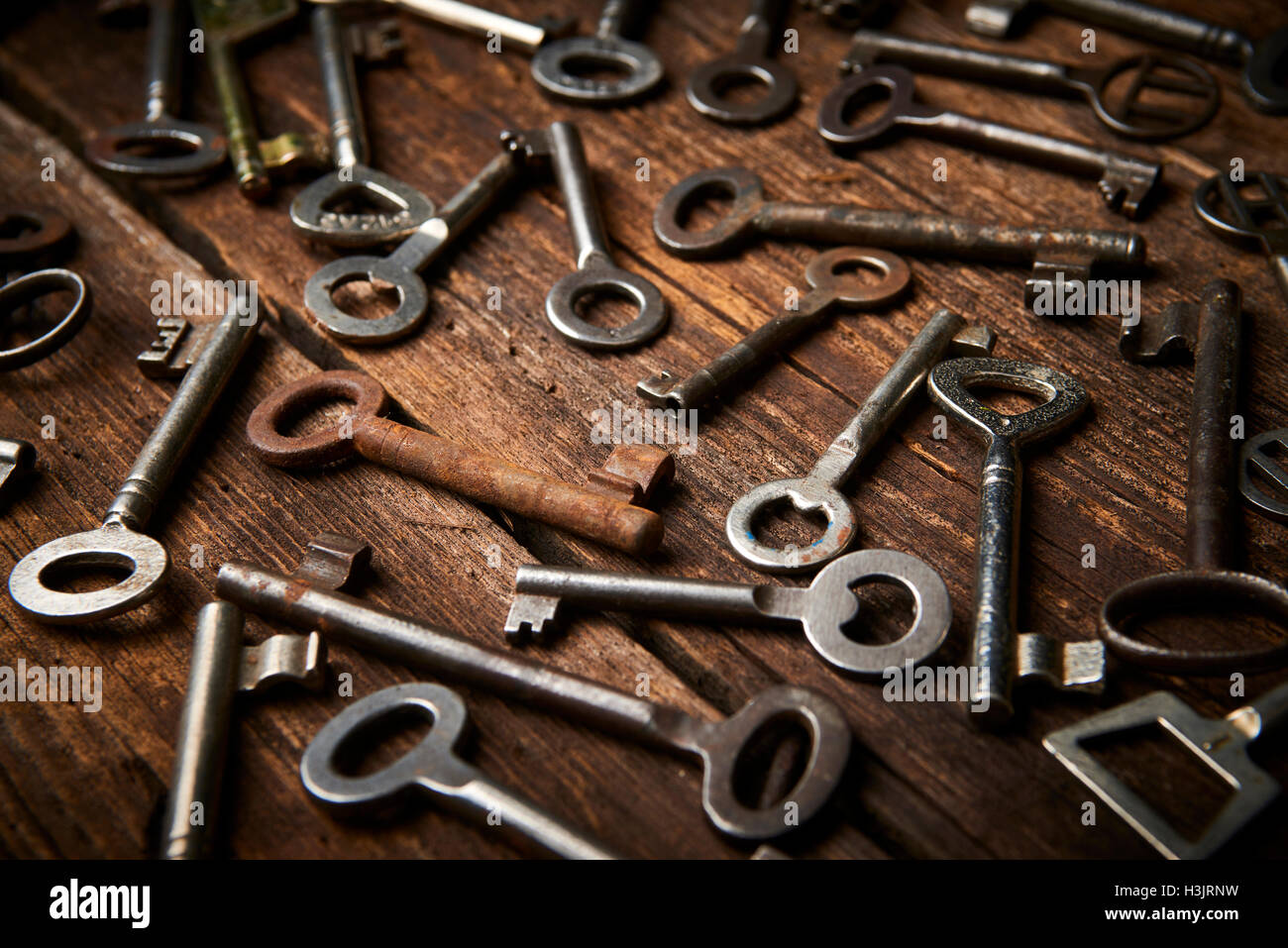 many different keys on brown wooden background Stock Photo - Alamy