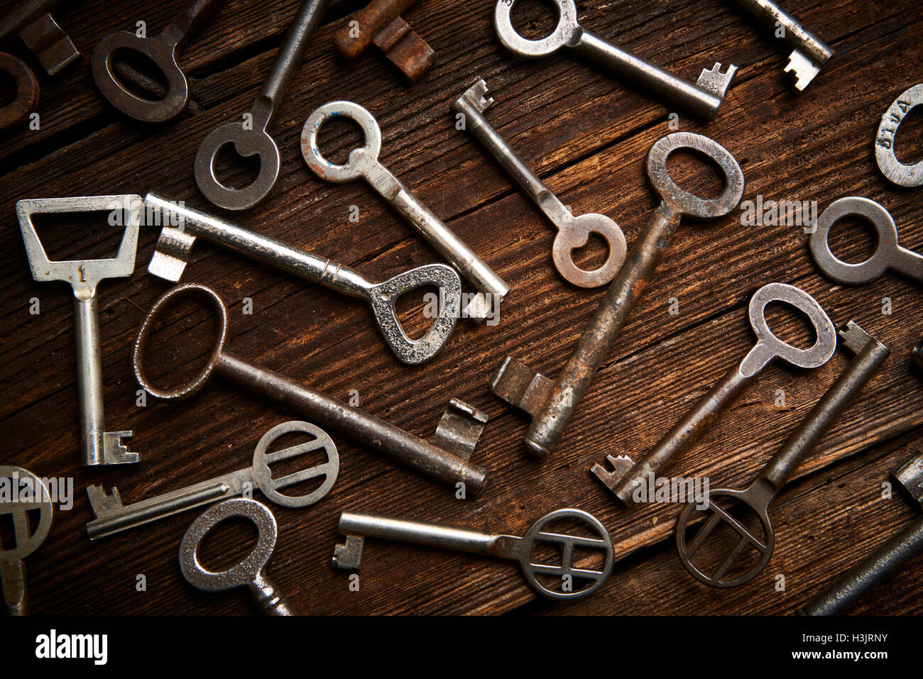 many different keys on brown wooden background Stock Photo - Alamy