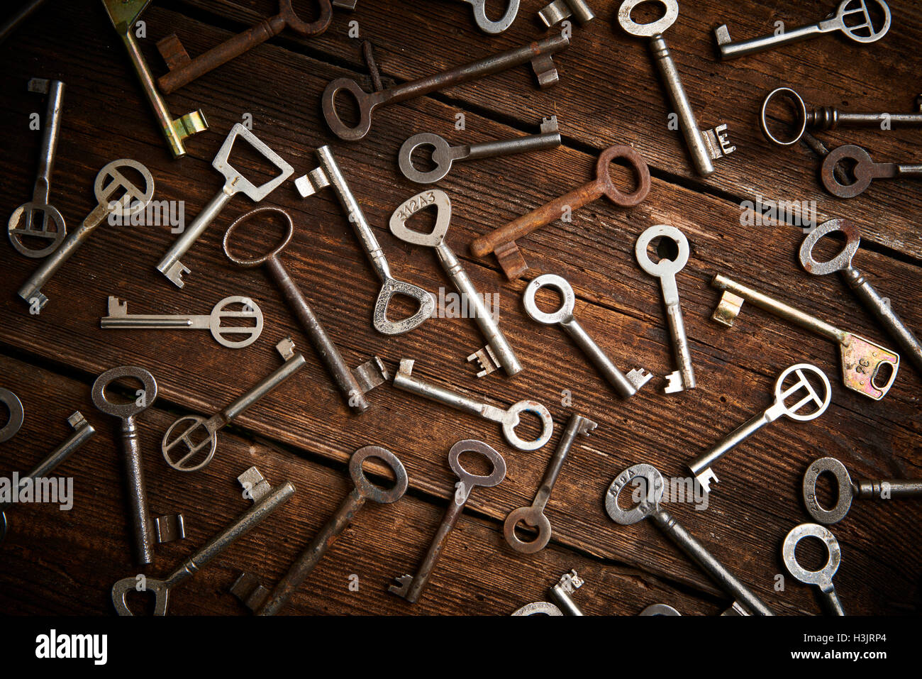 many different keys on brown wooden background Stock Photo - Alamy
