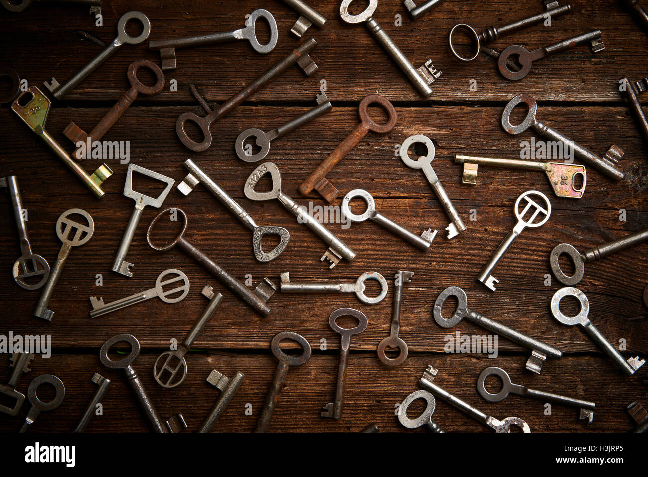 many different keys on brown wooden background Stock Photo - Alamy