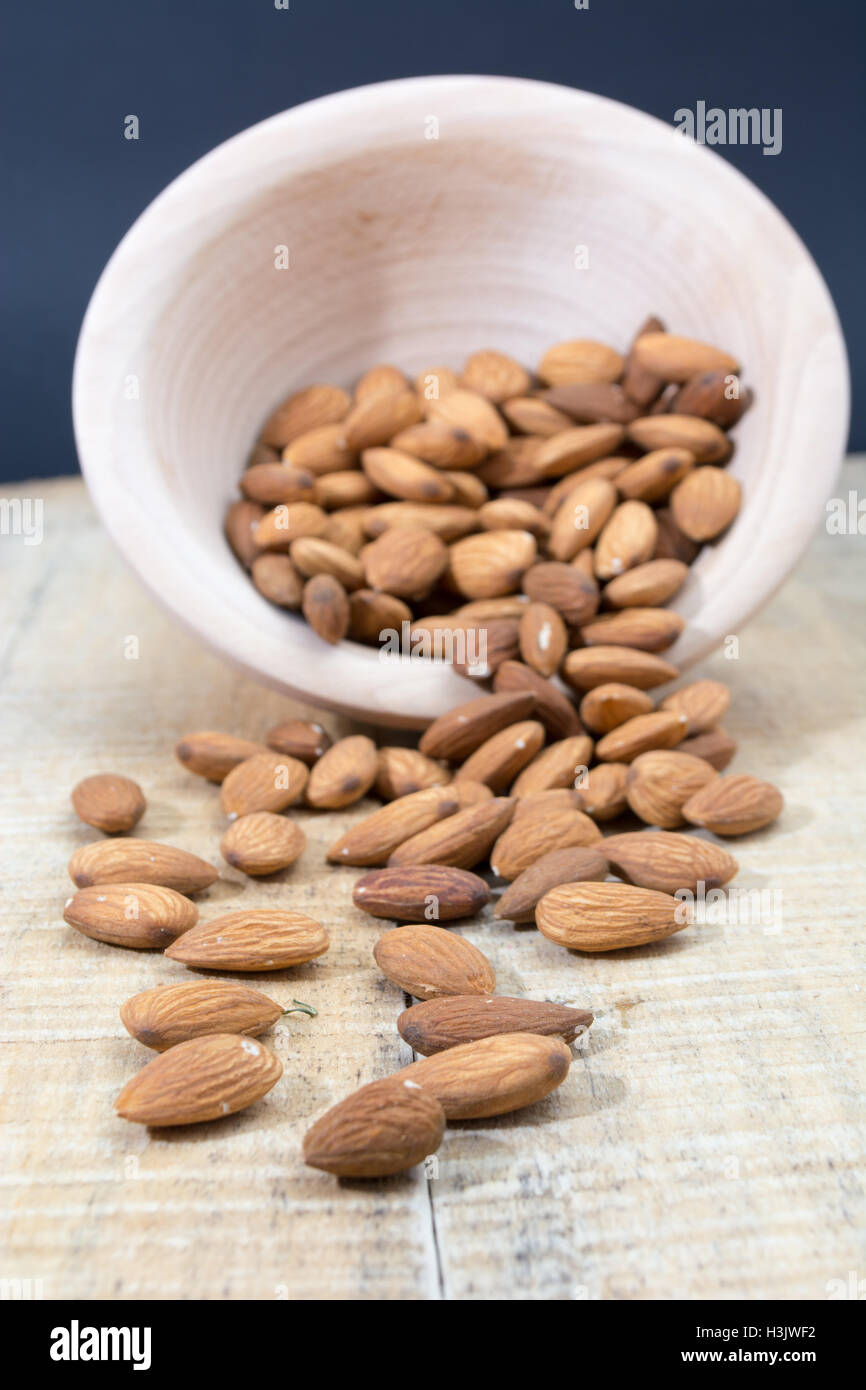 Spilled almonds out of the bowl on the table Stock Photo - Alamy