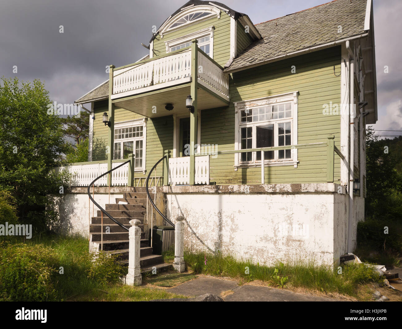 Stately old green and white clapboard villa in a state of disrepair ...
