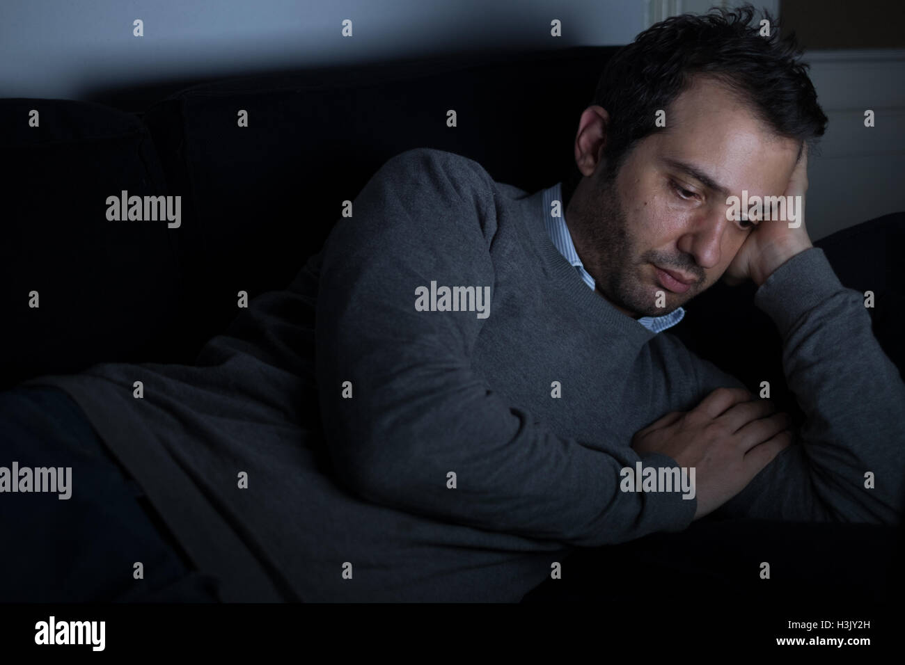 Sad man sitting in dark hi-res stock photography and images - Alamy