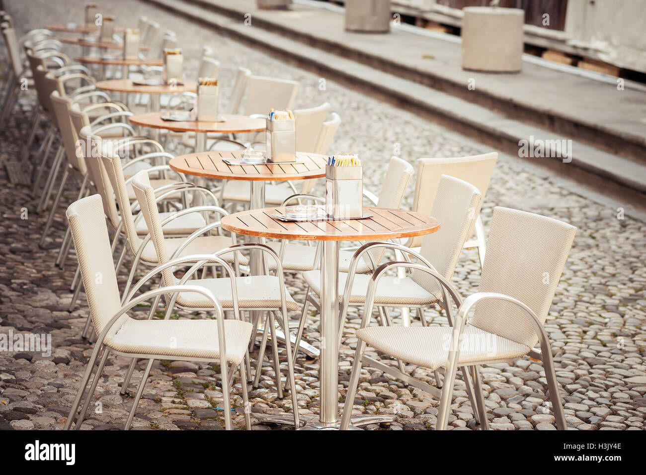 A row of small tables of a café on a pedestrian street Stock Photo - Alamy