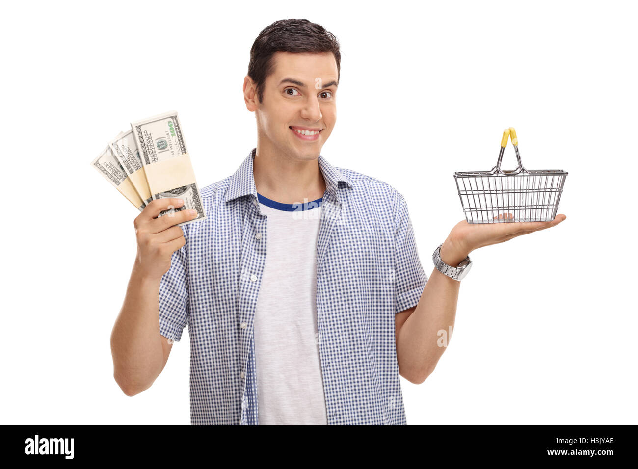 Happy guy holding a small empty shopping basket and bundles of money ...