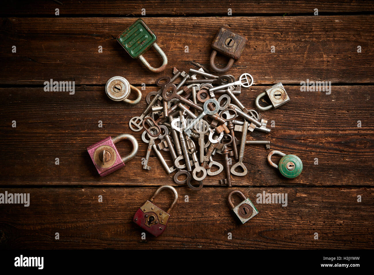 Group of old rusty padlocks with pile of keys on brown wooden table ...