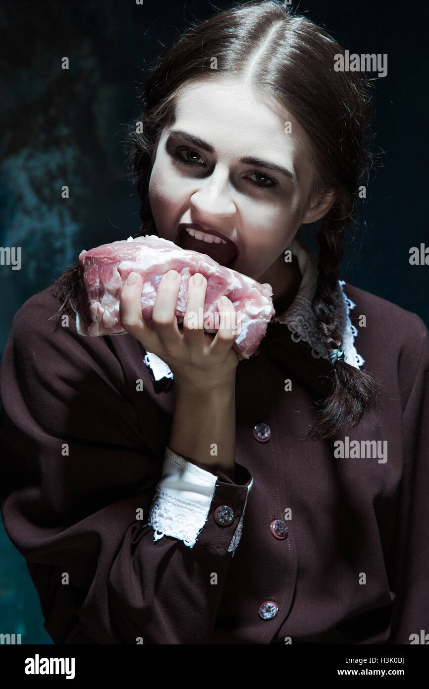 Bloody Halloween theme: crazy girl with raw meat Stock Photo - Alamy