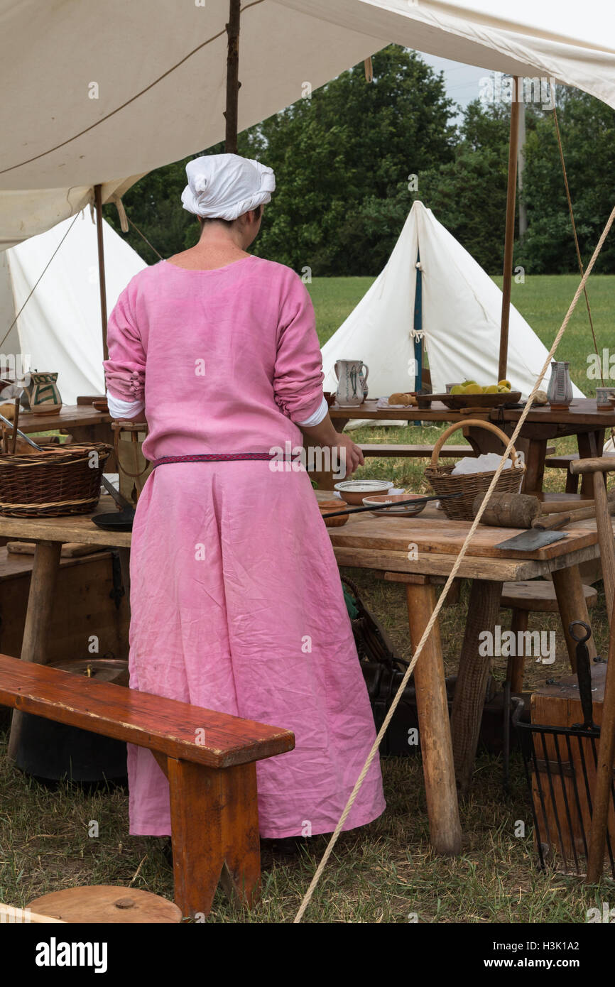Woman with Pink Tunic preparing Black Pan for Cooking inside Tent Stock ...