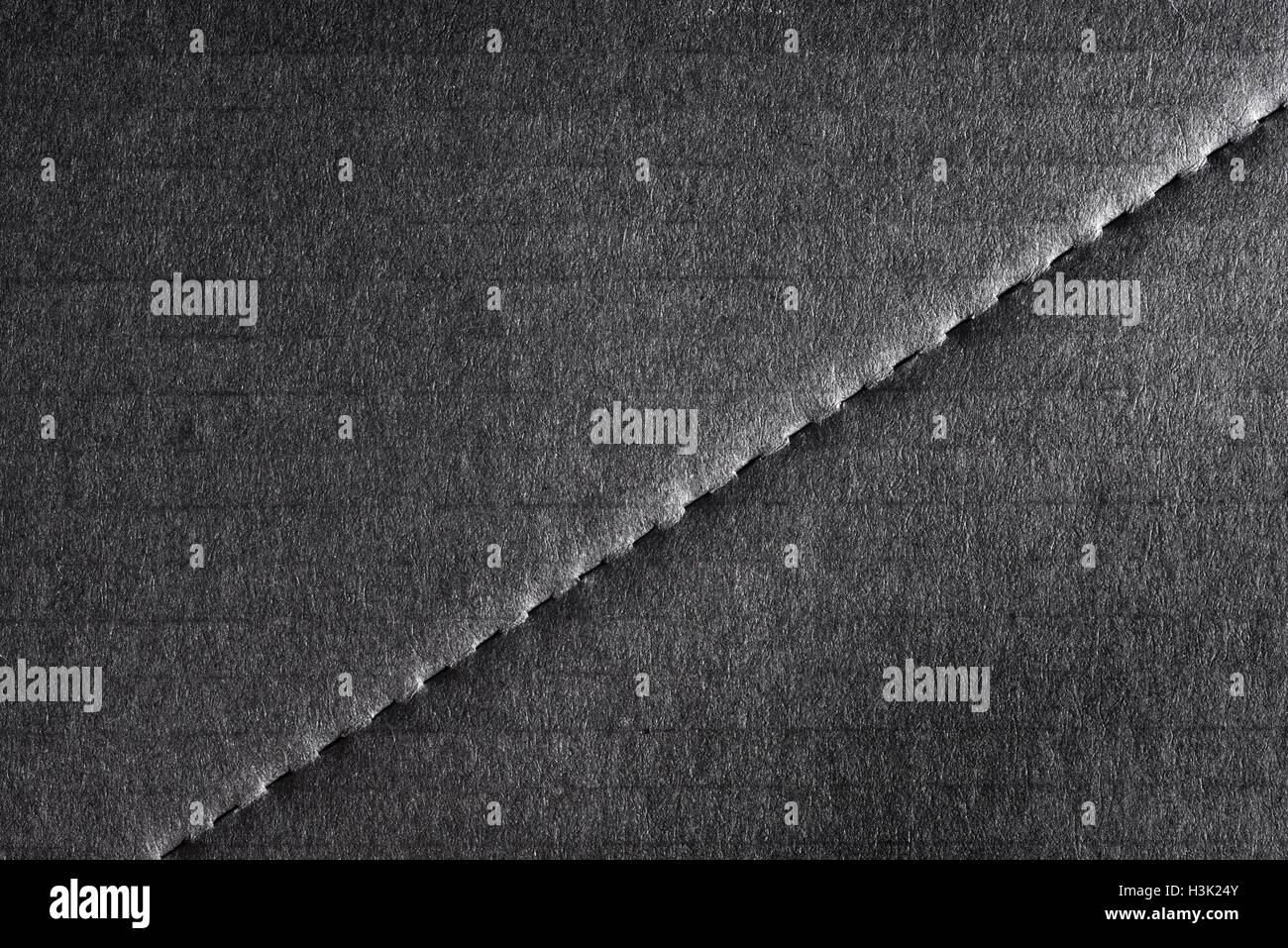 Black background made with cardboard material with a diagonal dashhed ...